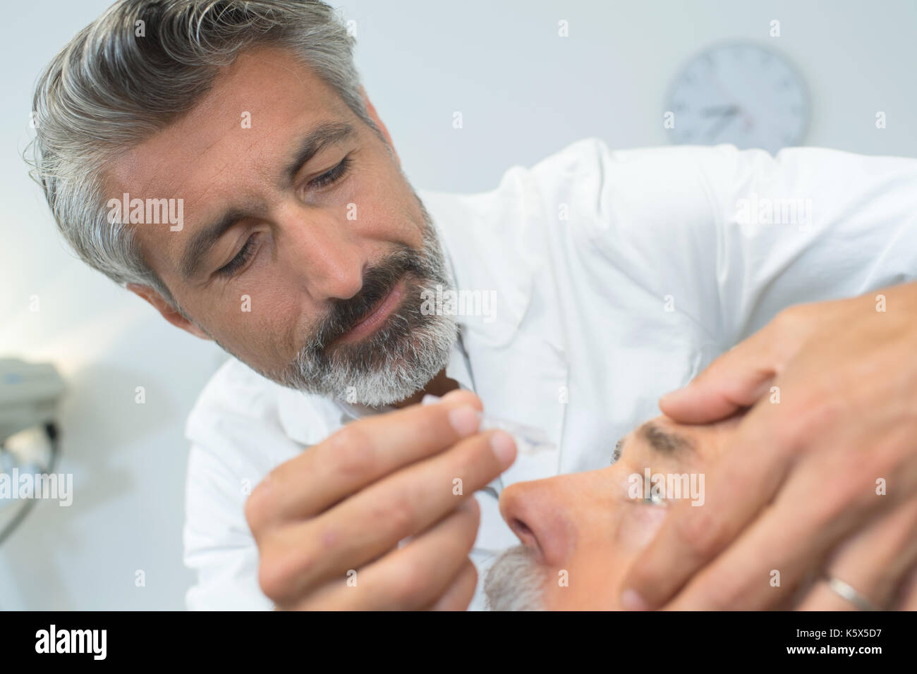 Doctor putting drops in patient's eye Stock Photo - Alamy