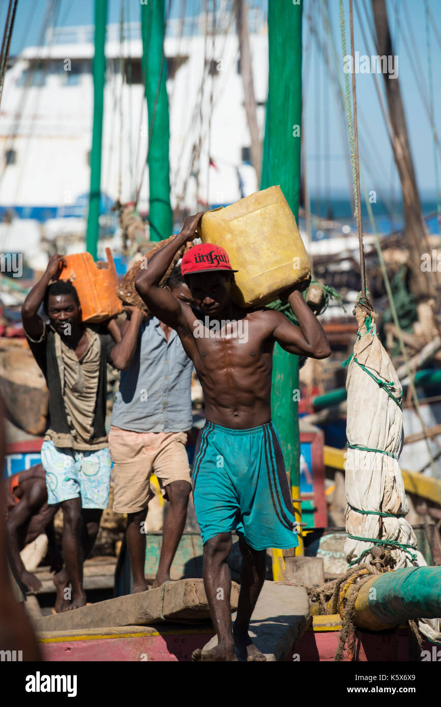Men off-loading cargo from dhow in the old dhow harbour, Mahajanga ...