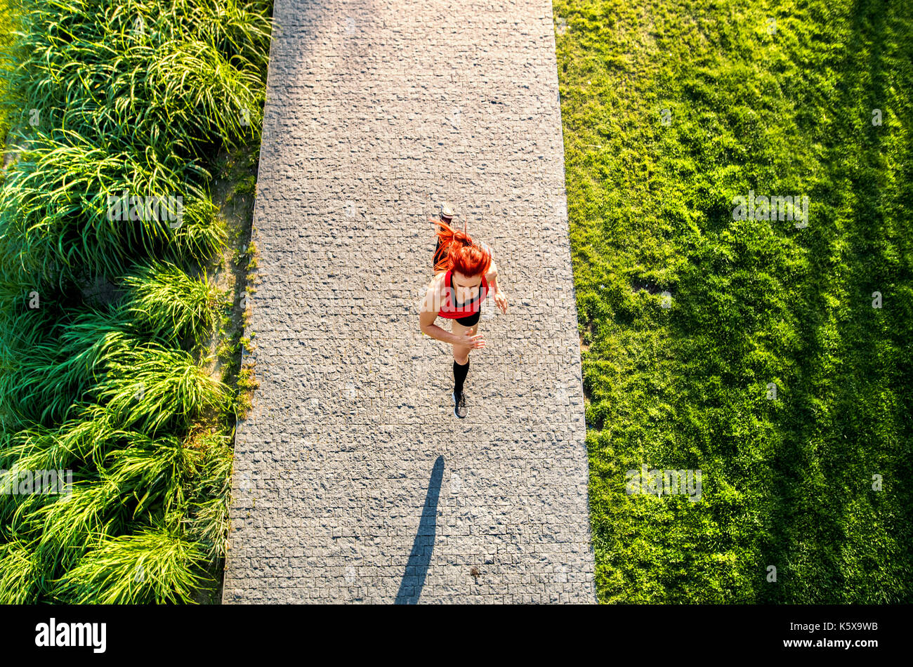 Beautiful young athlete running on a path in park Stock Photo - Alamy
