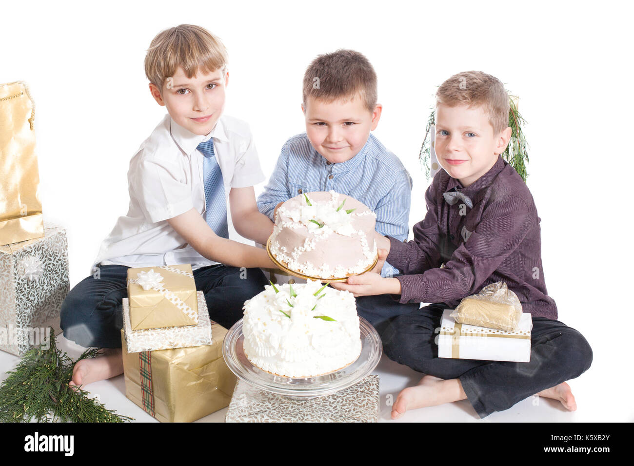 boys holding a cake among gifts Stock Photo - Alamy
