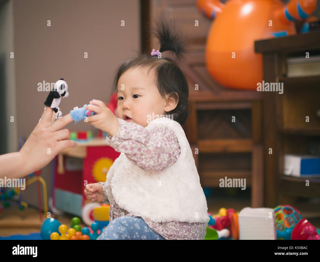 baby girl playing puppet at home Stock Photo - Alamy
