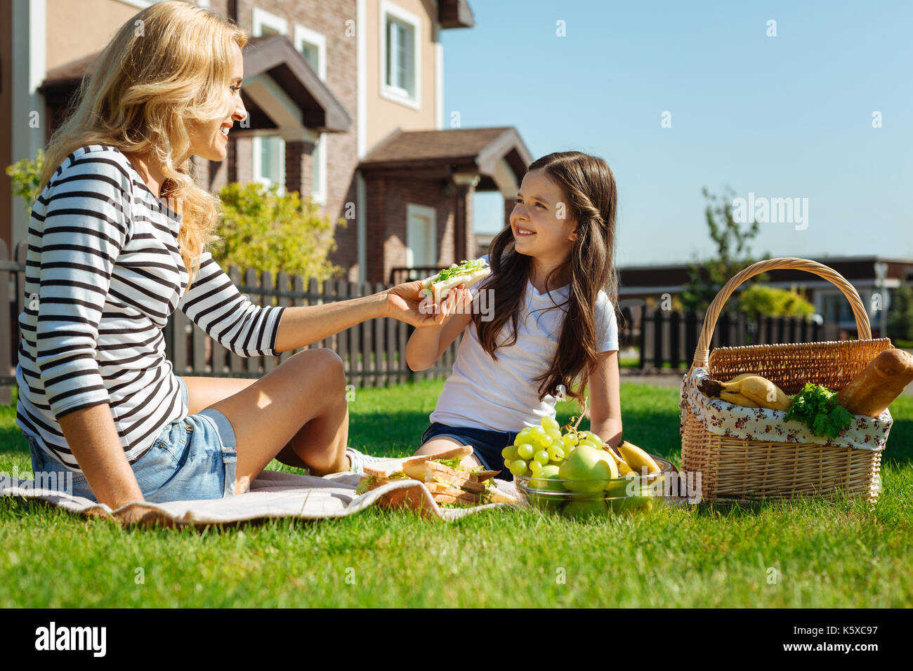 Caring mother giving her daughter a sandwich on picnic Stock Photo - Alamy