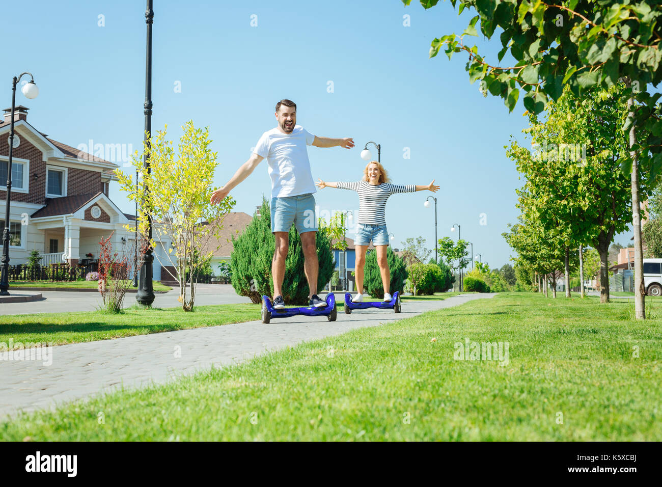 Happy young couple enjoying hoverboard ride Stock Photo - Alamy