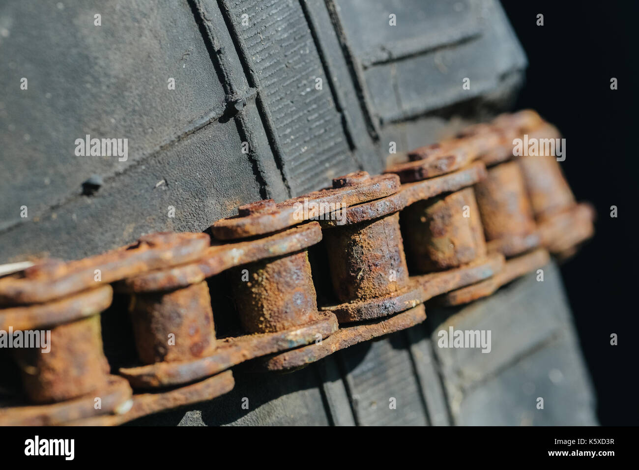 Tire roll up a rusty chain Stock Photo - Alamy