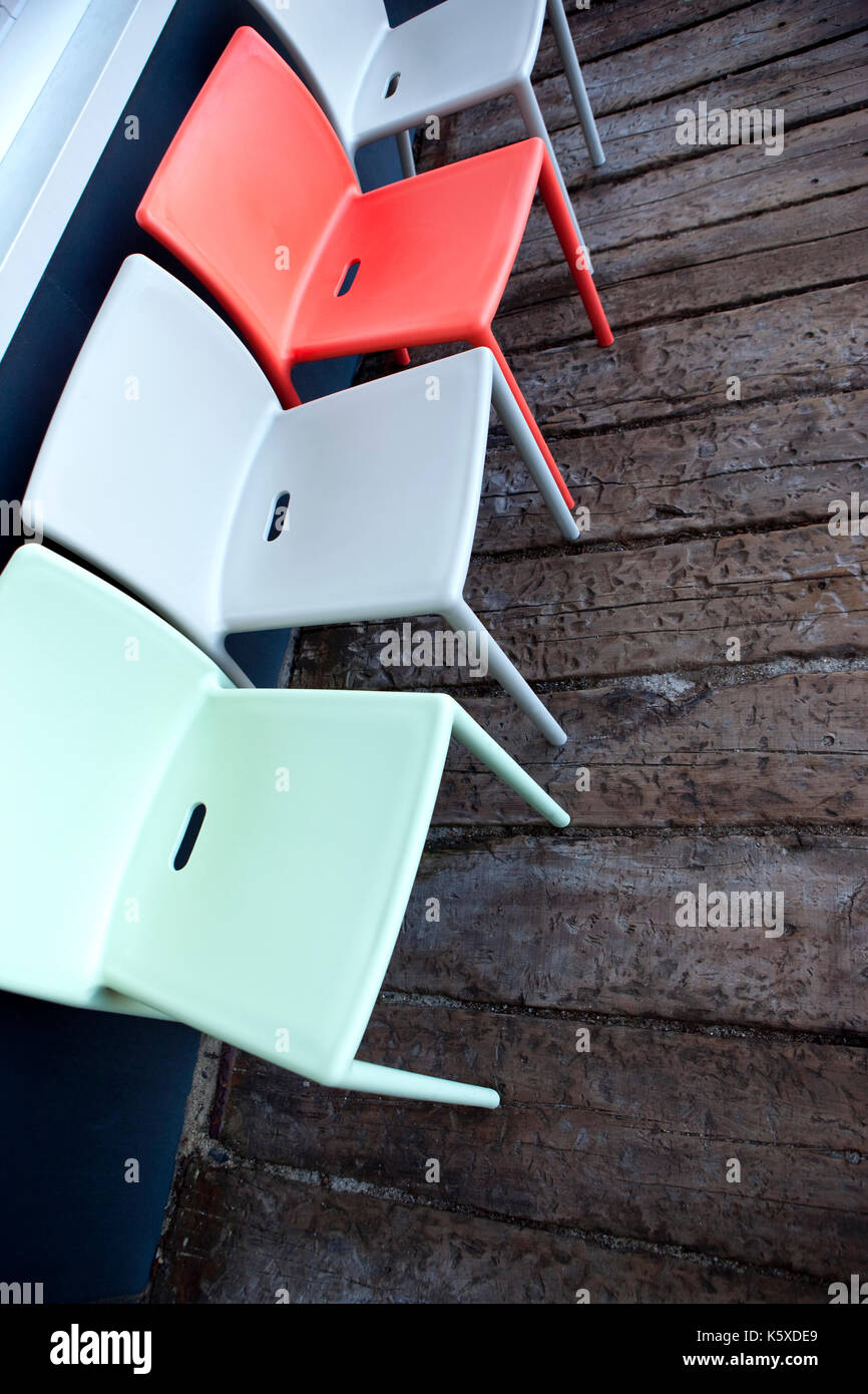 Plastic chairs on a wooden floor in a courtyard Stock Photo - Alamy
