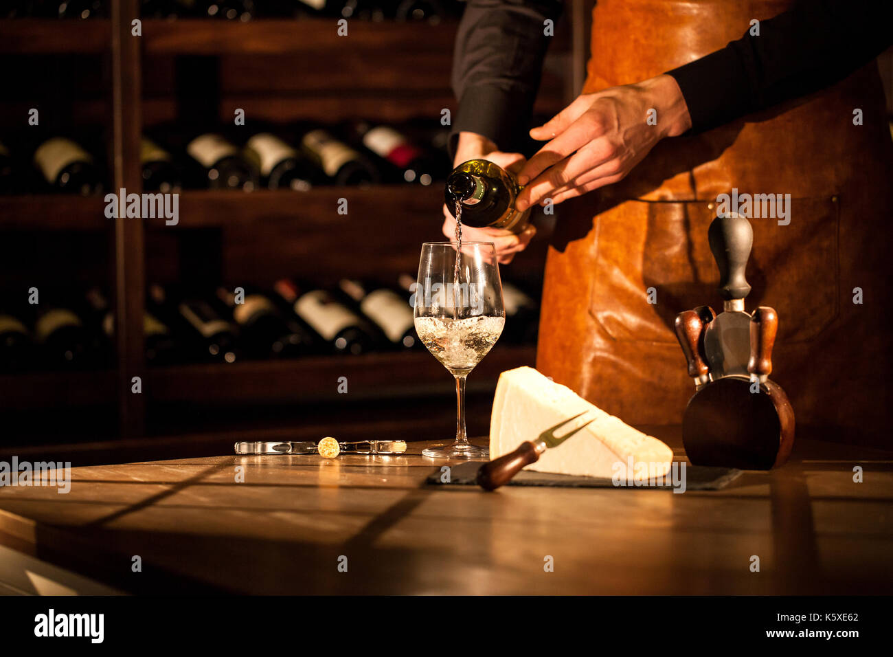 Sommelier pouring wine into a glass from a bottlet. Wine vault Stock ...