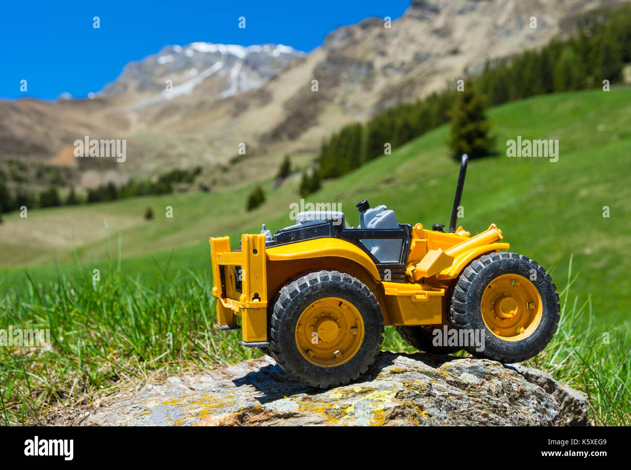 small toy tractor on rock in mountain Stock Photo - Alamy