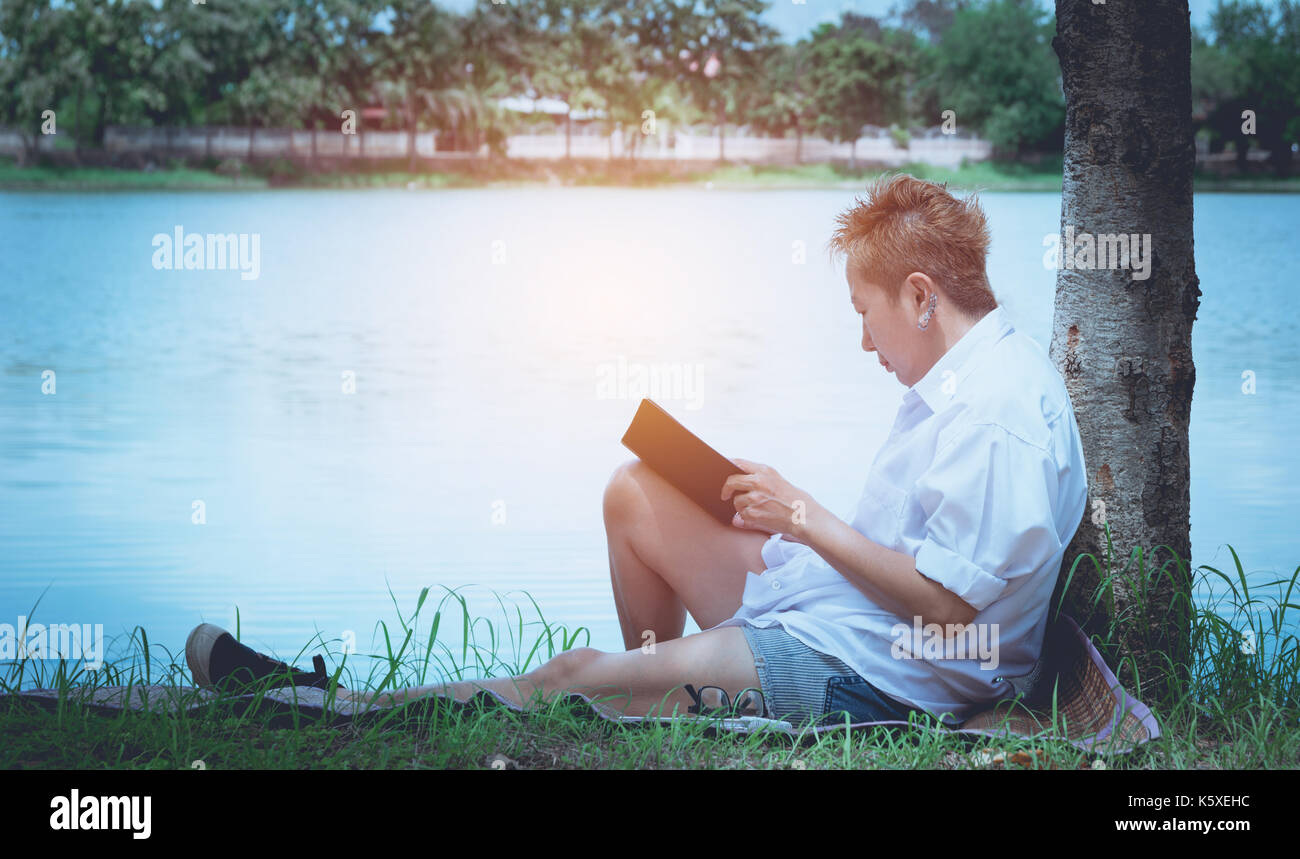 woman reading a book enjoys of rest. Woman hand holding a book for read ...