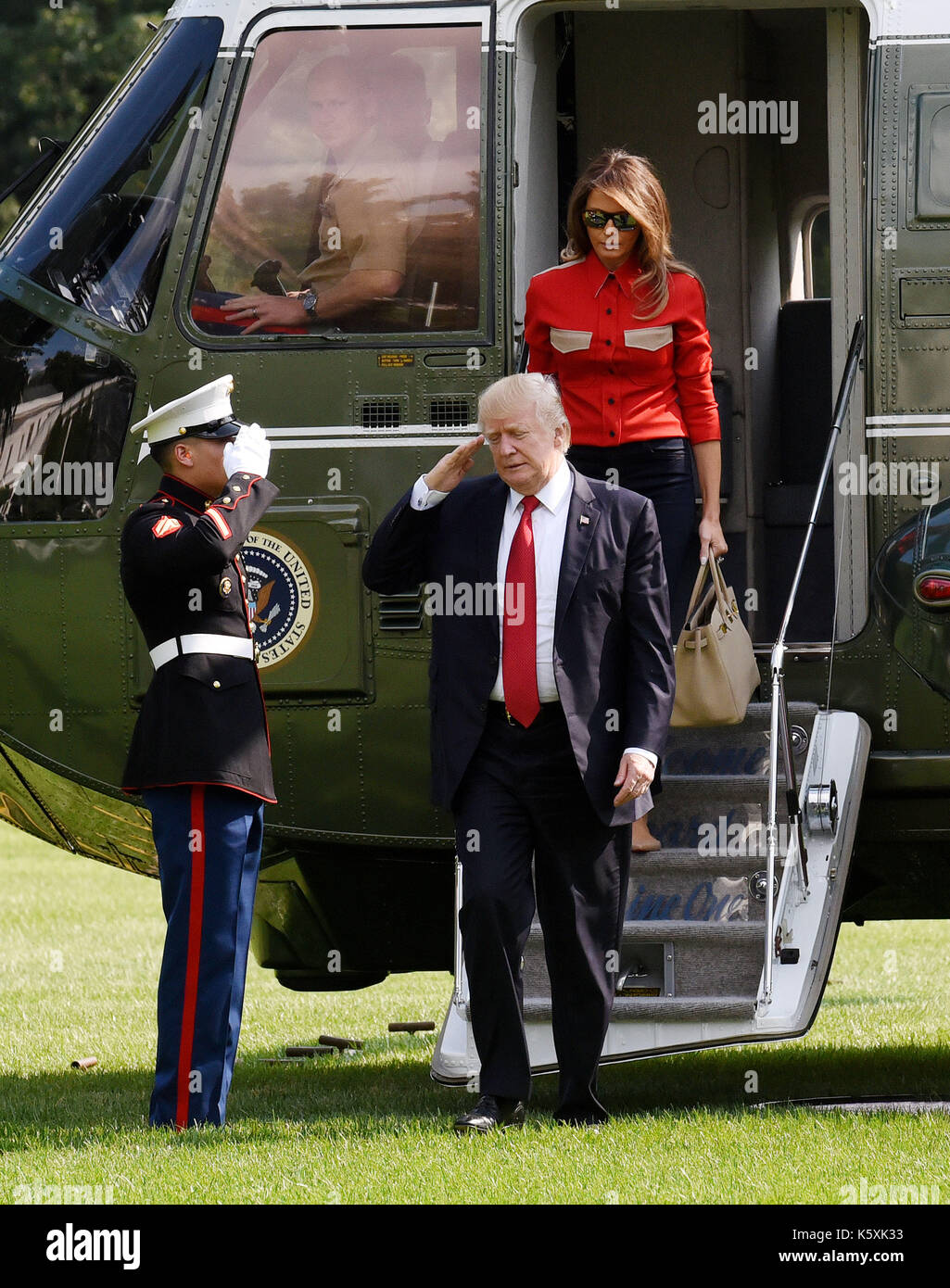 United States President Donald J. Trump salutes the Marine Guard as he ...