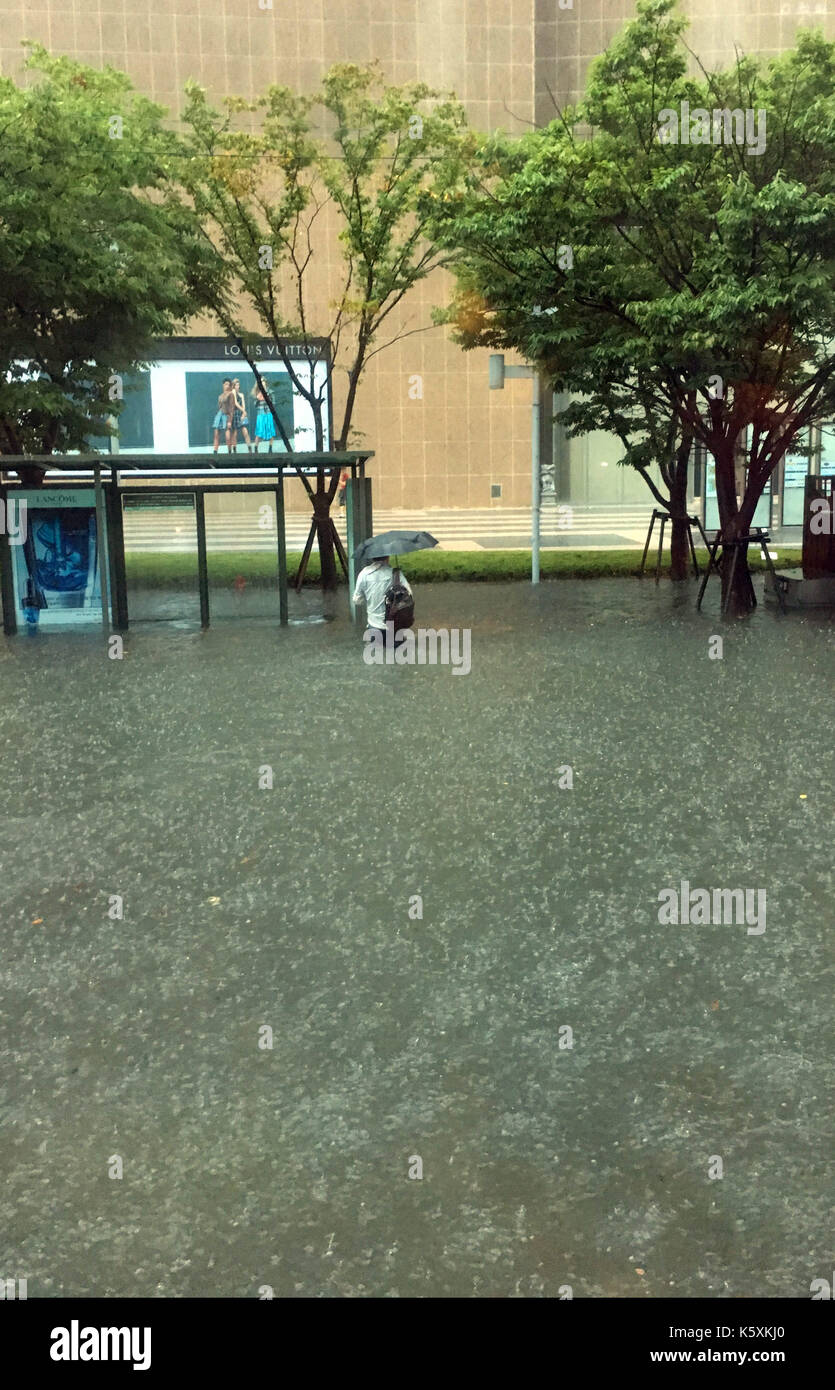 Flooded roads in Busan A man wades through flood water on a road in ...