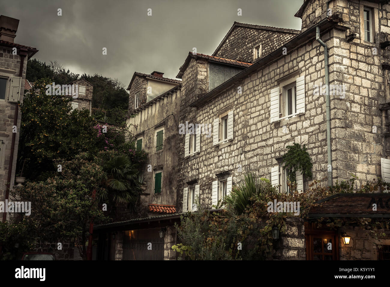 Vintage medieval city street with stone building exterior in overcast ...