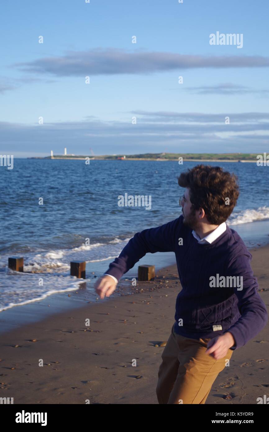 Smartly Dressed Young Man Throwing a Stone into the North Sea. Aberdeen ...
