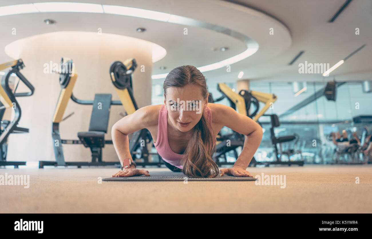 Woman doing push-up in gym for better fitness Stock Photo - Alamy