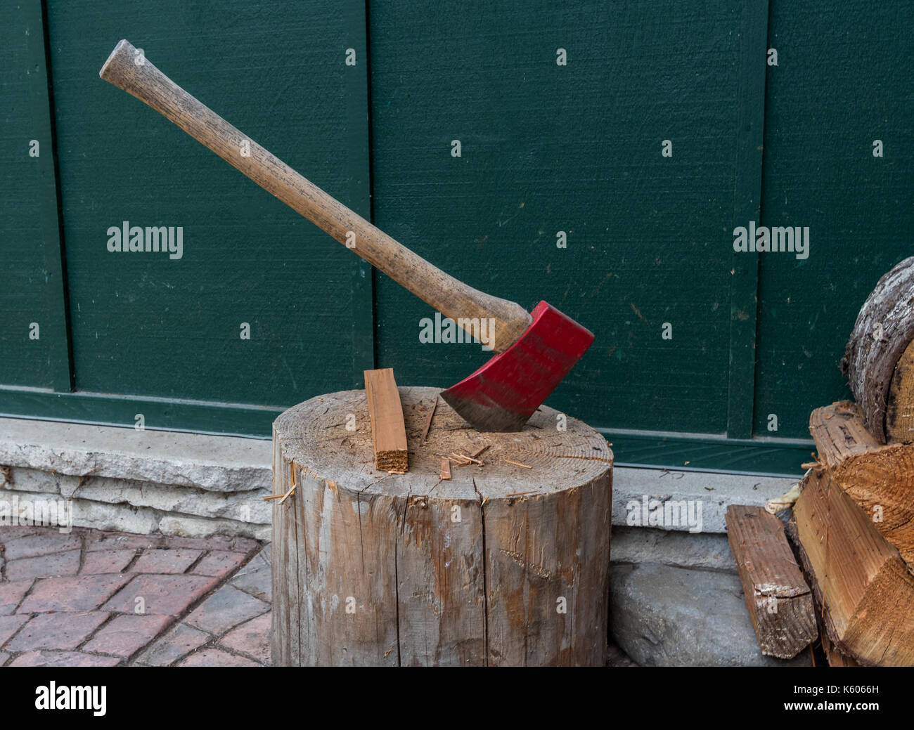 Red Axe In Log next to wood pile for indoor fireplace Stock Photo - Alamy