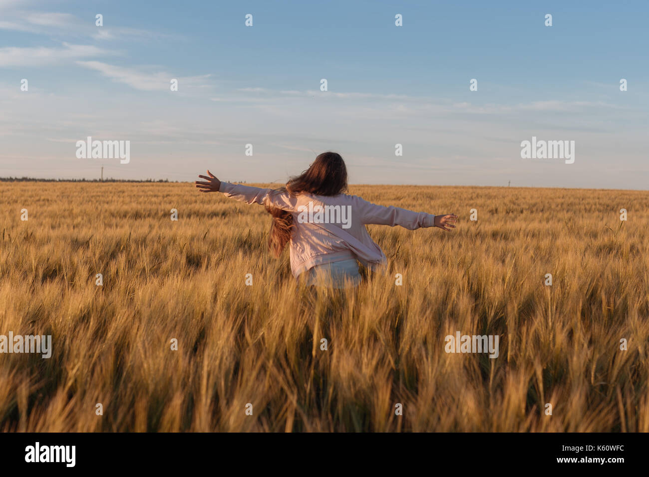 Teenage girl running in yellow field Stock Photo - Alamy