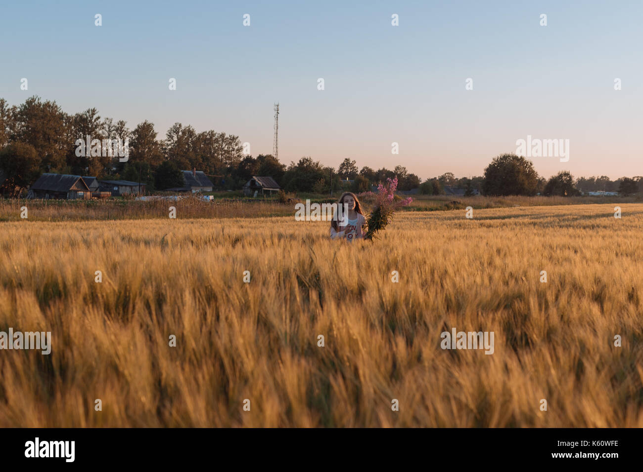 Teen girl in a field with flowers Stock Photo - Alamy