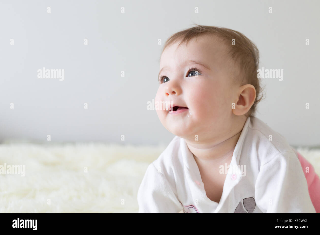 Small child smiles and looks to the side. Closeup portrait in the home ...