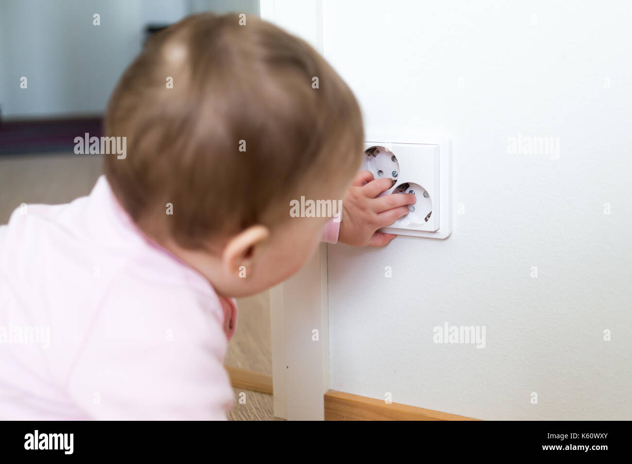 Small child touches an electrical outlet at home. Safety of children ...