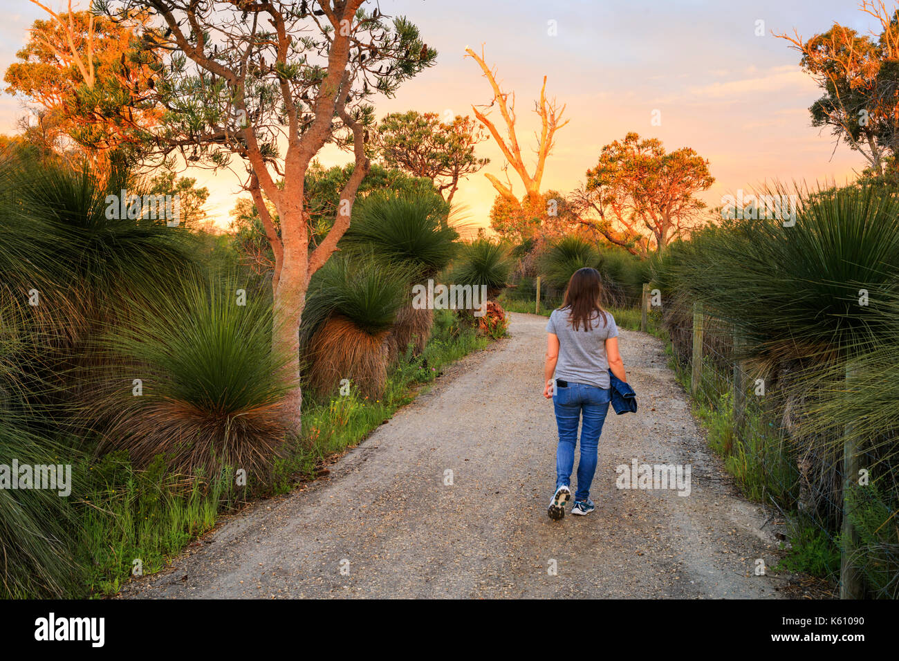 Woman walking down a path through Star Swamp Reserve Reserve suburban ...