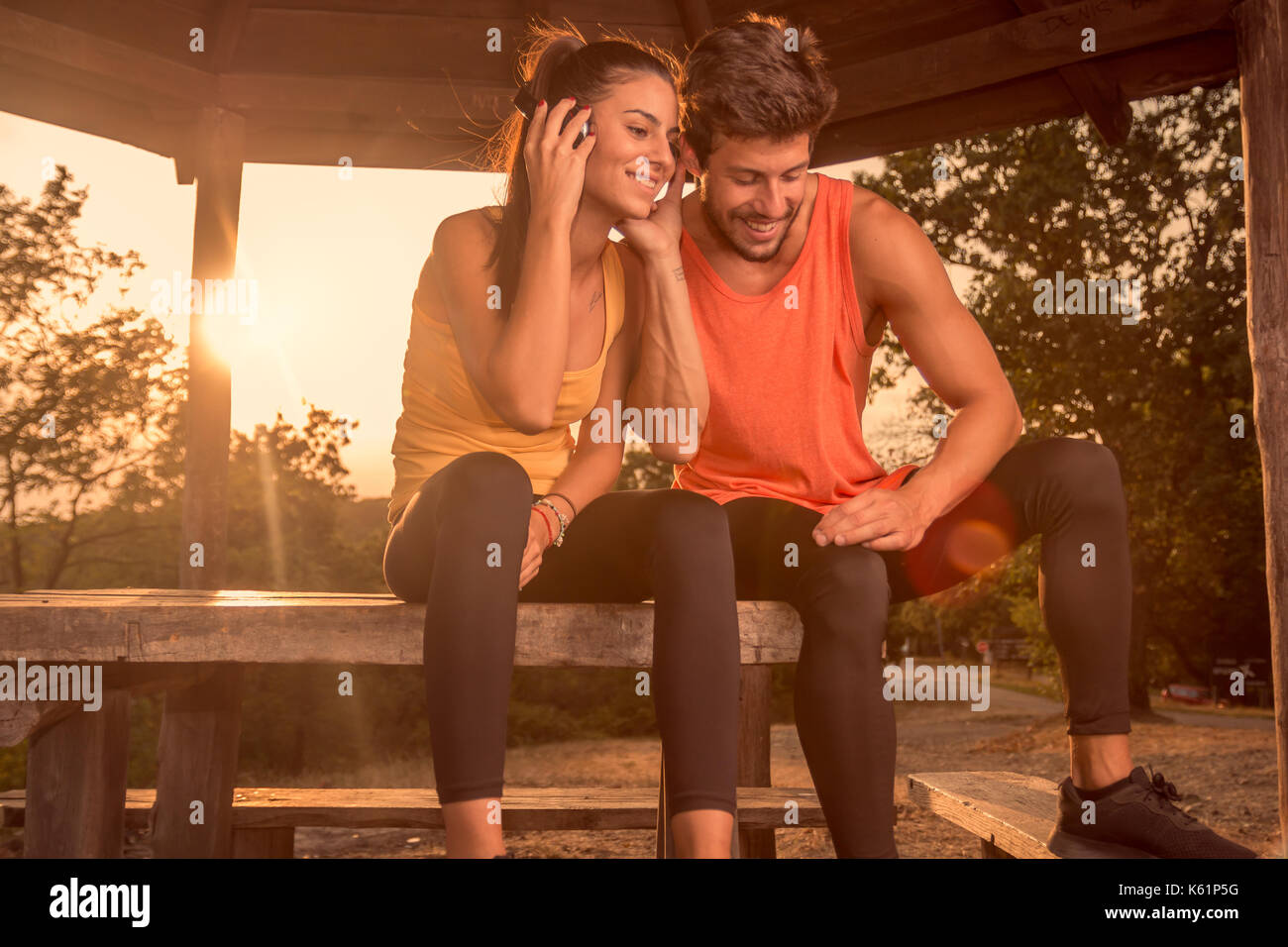 two young people, man woman, sitting together wood table, outdoors ...
