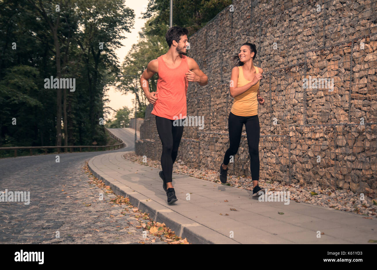 two young adult people, jogging, outdoors nature forest asphalt, sport ...