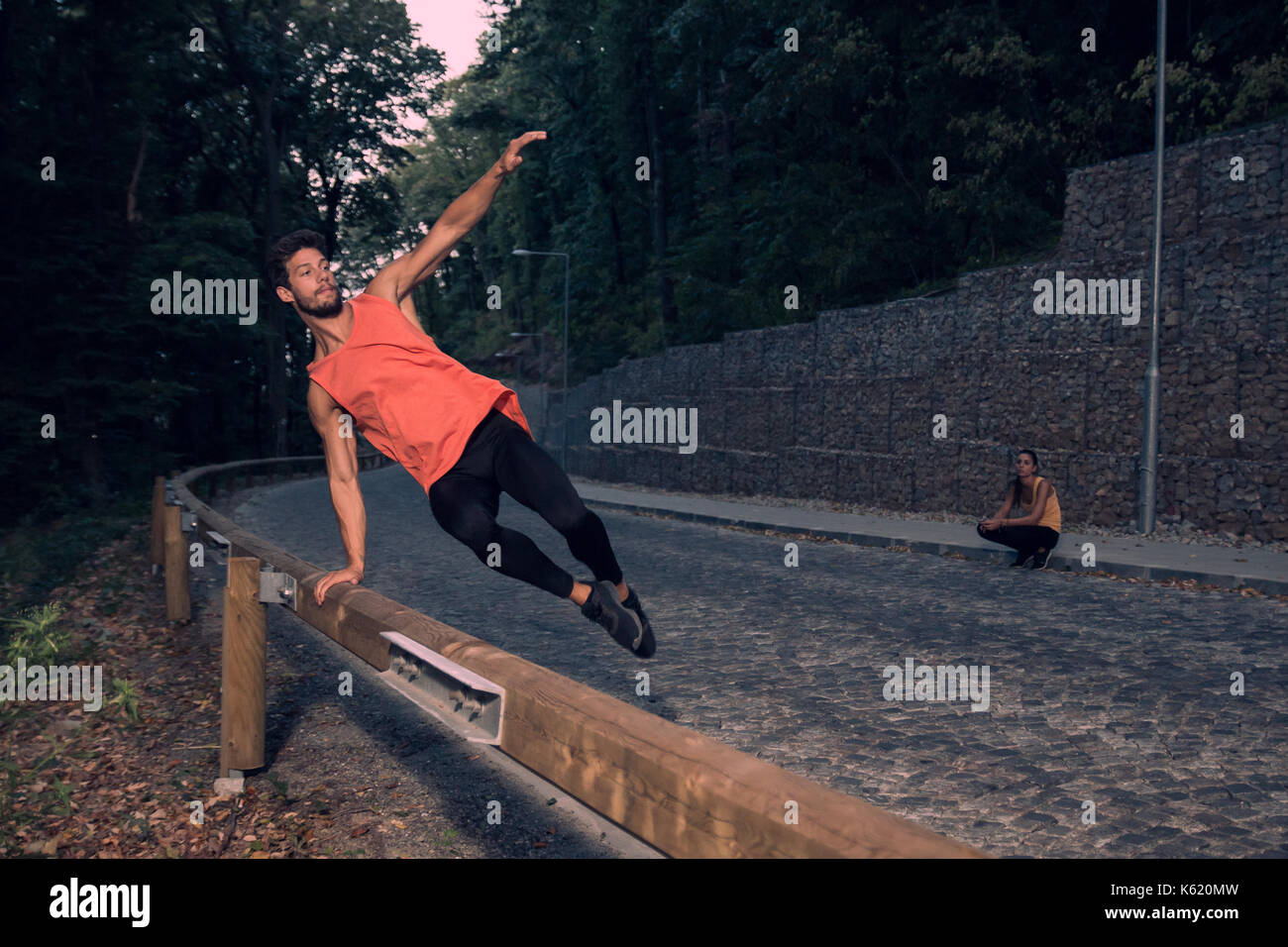 two young people, adventure, road forest outdoors, man jumping fence ...