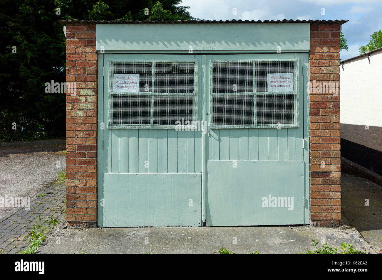Small double doored garage with metal covered windows Stock Photo - Alamy