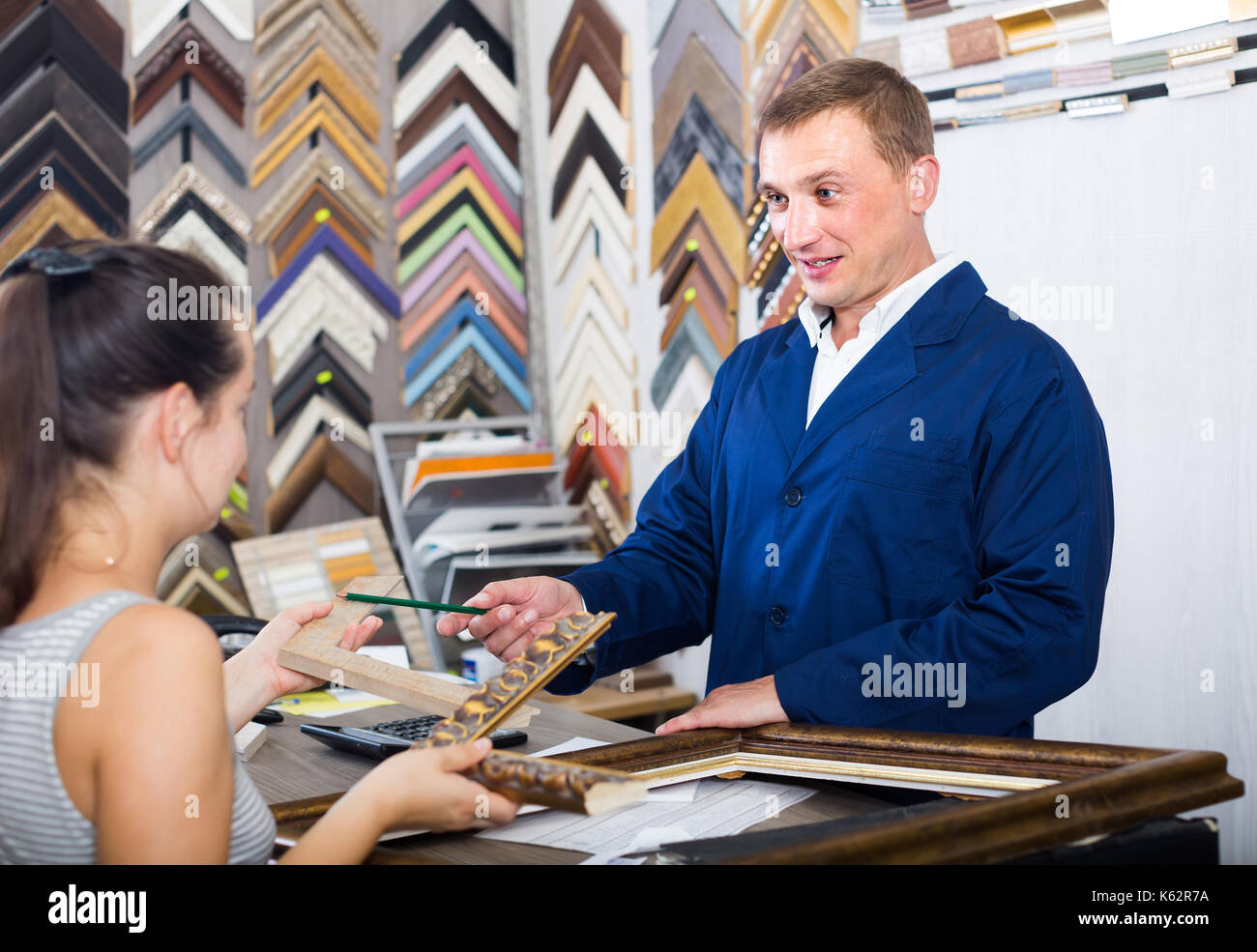 portrait of happy russian man seller taking order on picture frame from ...
