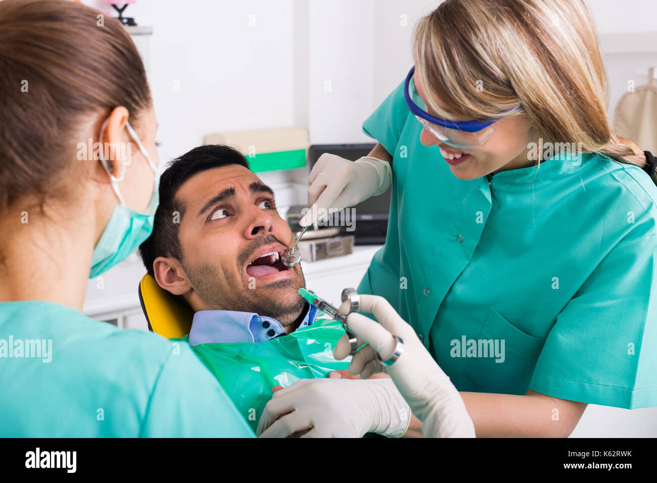 Portrait of doctor and frightened nervous patient at dental clinic ...