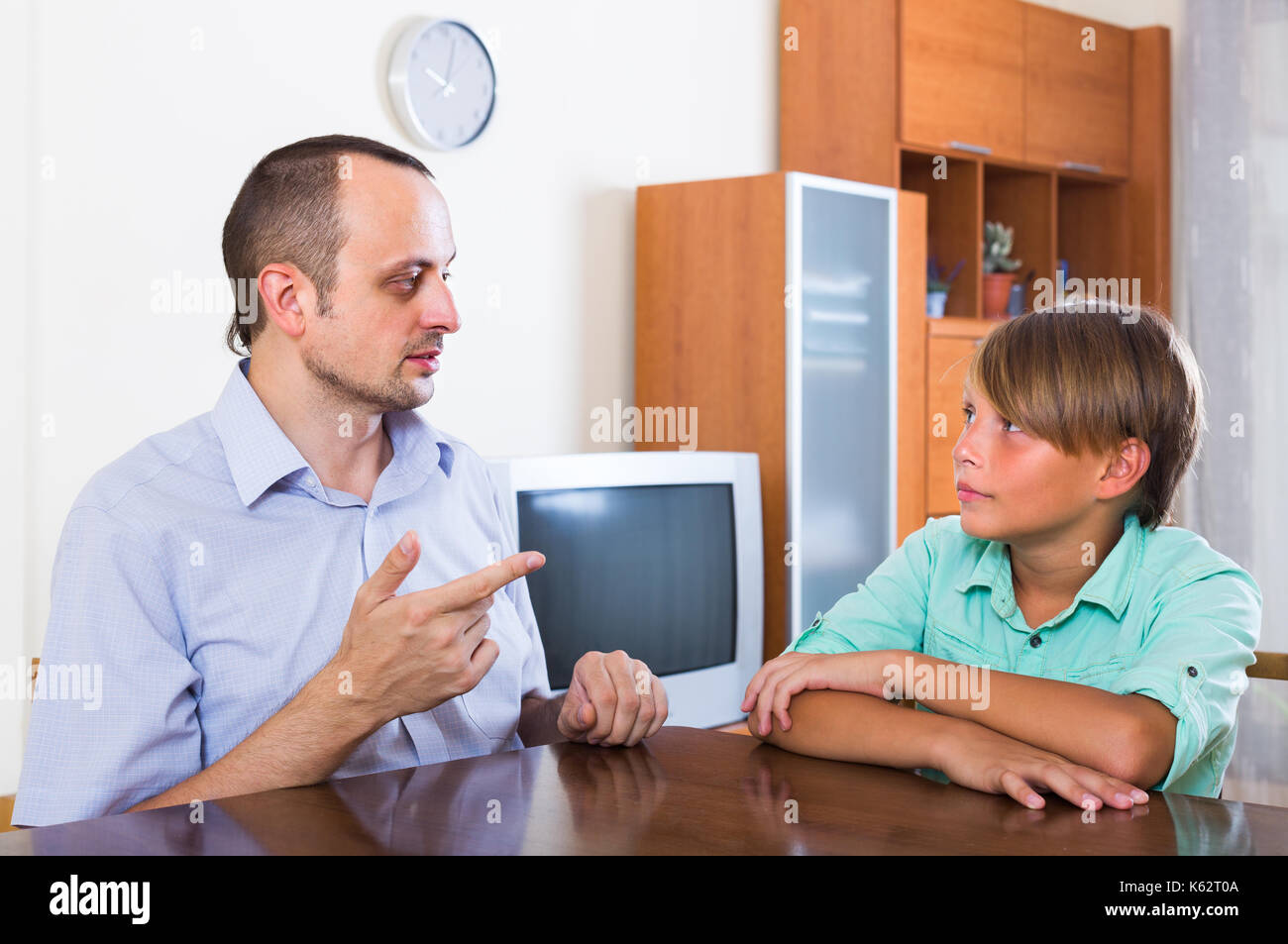 Portrait of father and boy having important conversation at home Stock ...