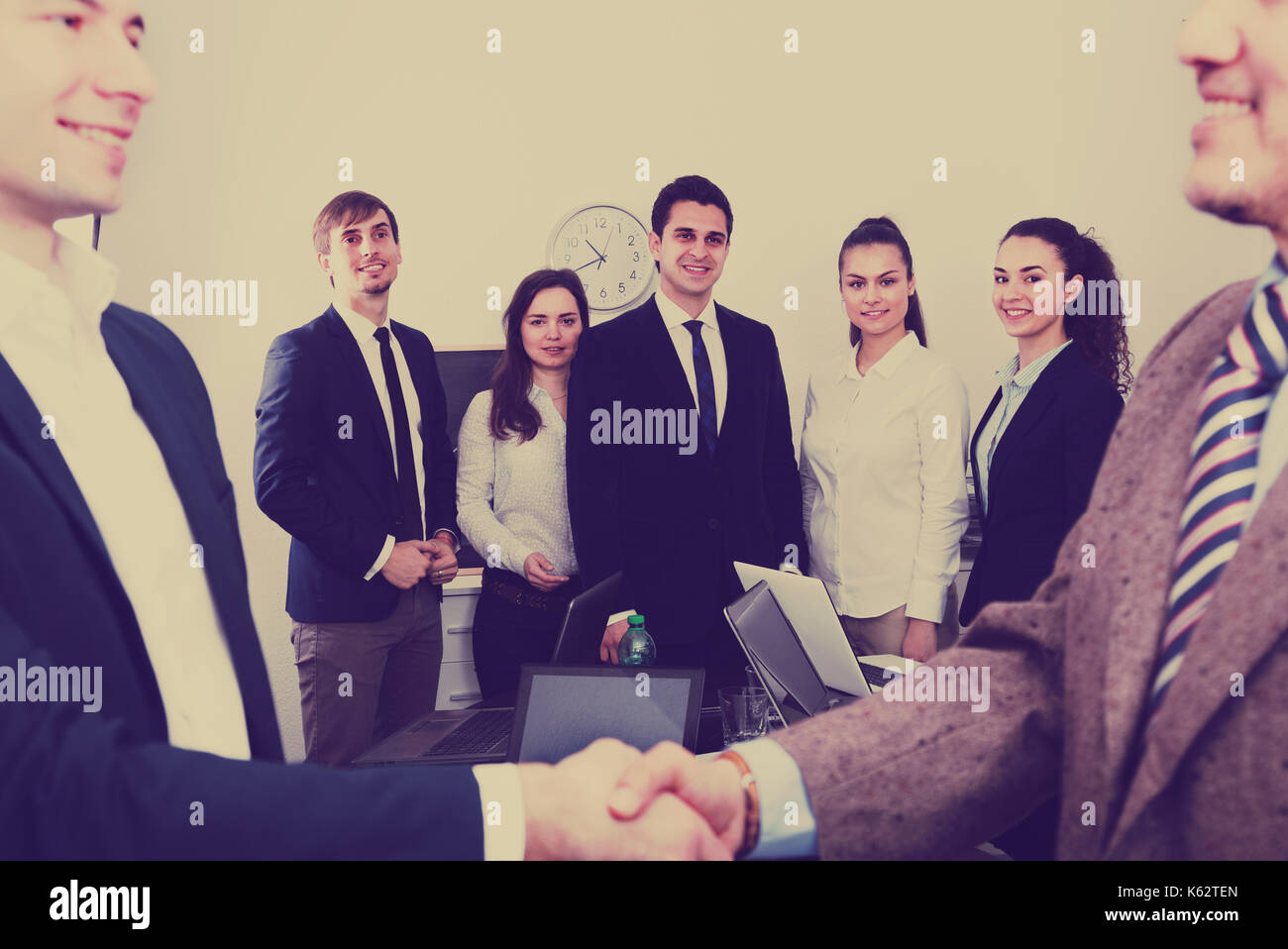 Two managers in suits shaking hands and celebrating successful deal ...