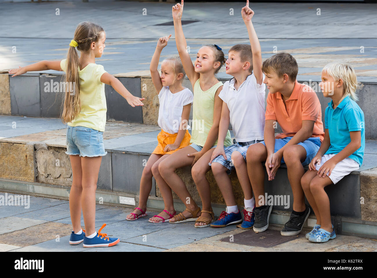 kids in school age playing charades outdoors Stock Photo - Alamy