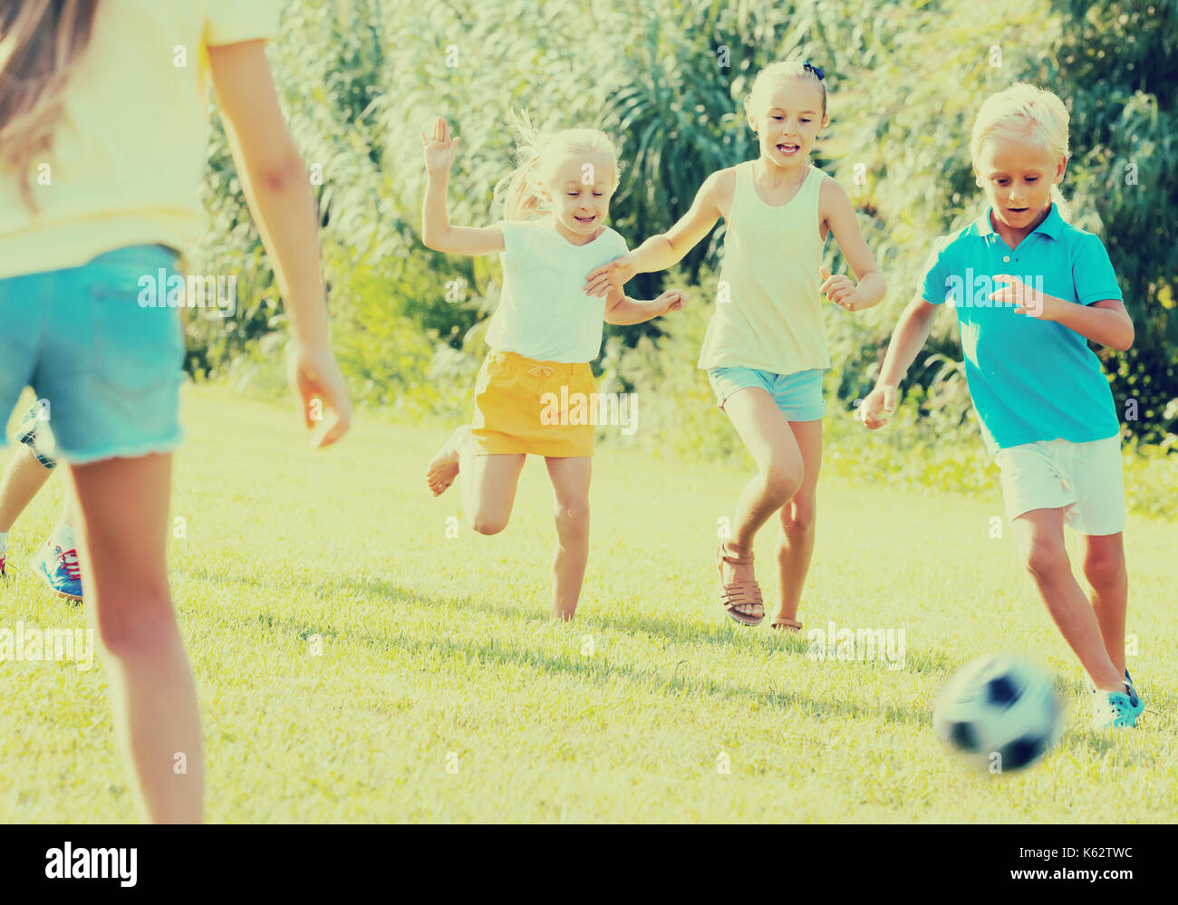 energetic children running with ball on meadow outdoors . Selective ...