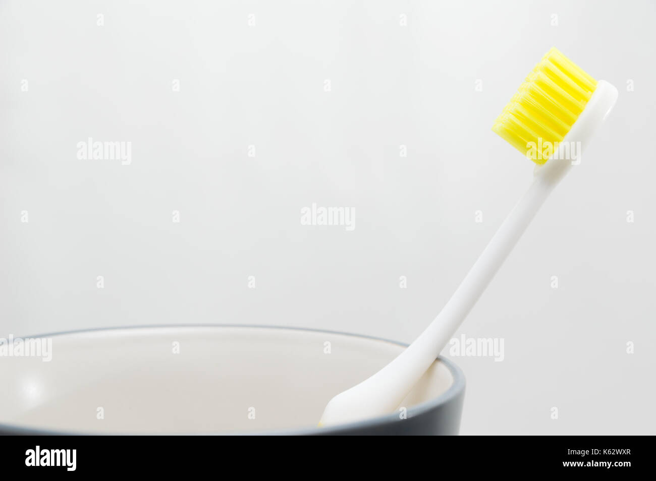 Toothbrush in cup on white background Stock Photo - Alamy