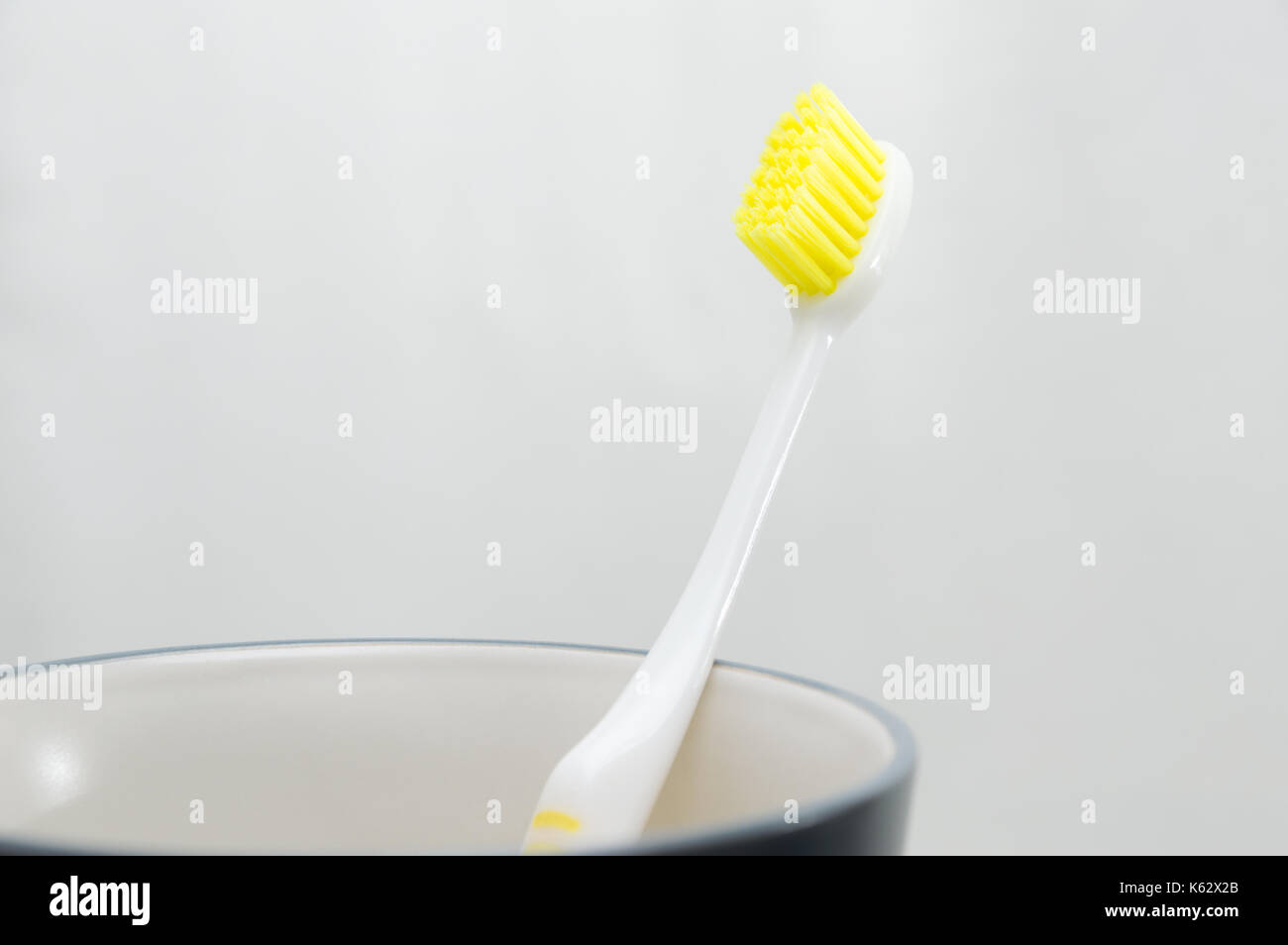 Toothbrush in cup on white background Stock Photo - Alamy