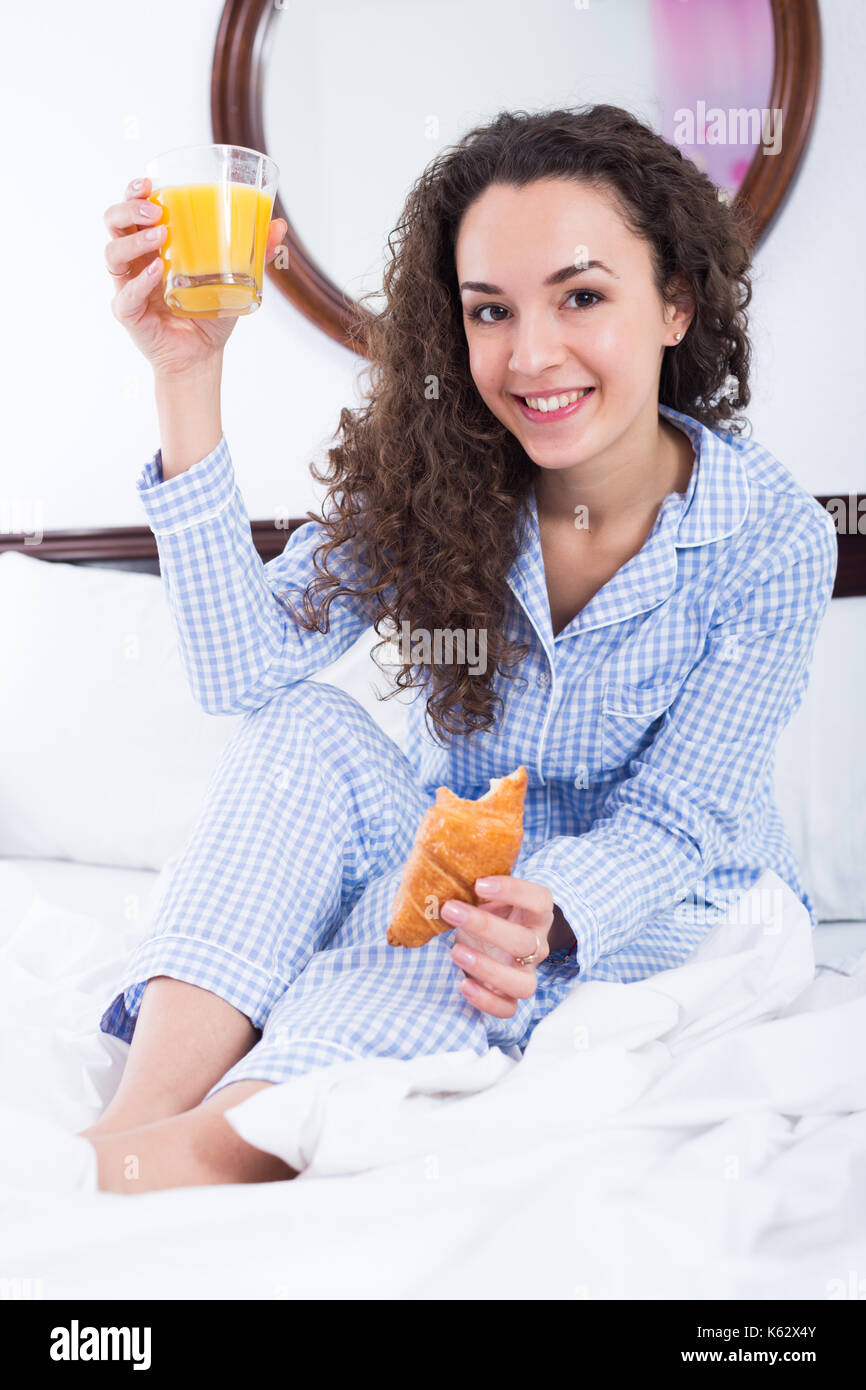 Adult female enjoying breakfast with fresh pastry in bed Stock Photo ...