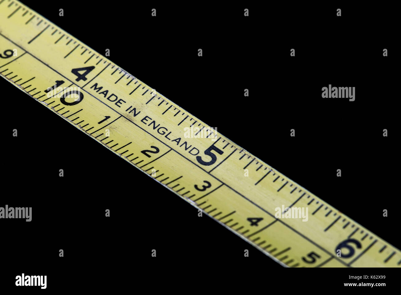 Yellow tape measure Close Up on black background Stock Photo - Alamy