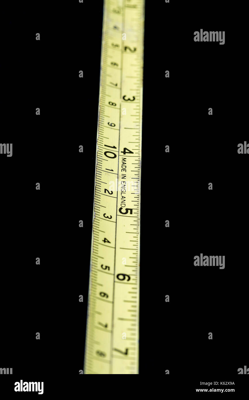 Yellow tape measure Close Up on black background Stock Photo - Alamy