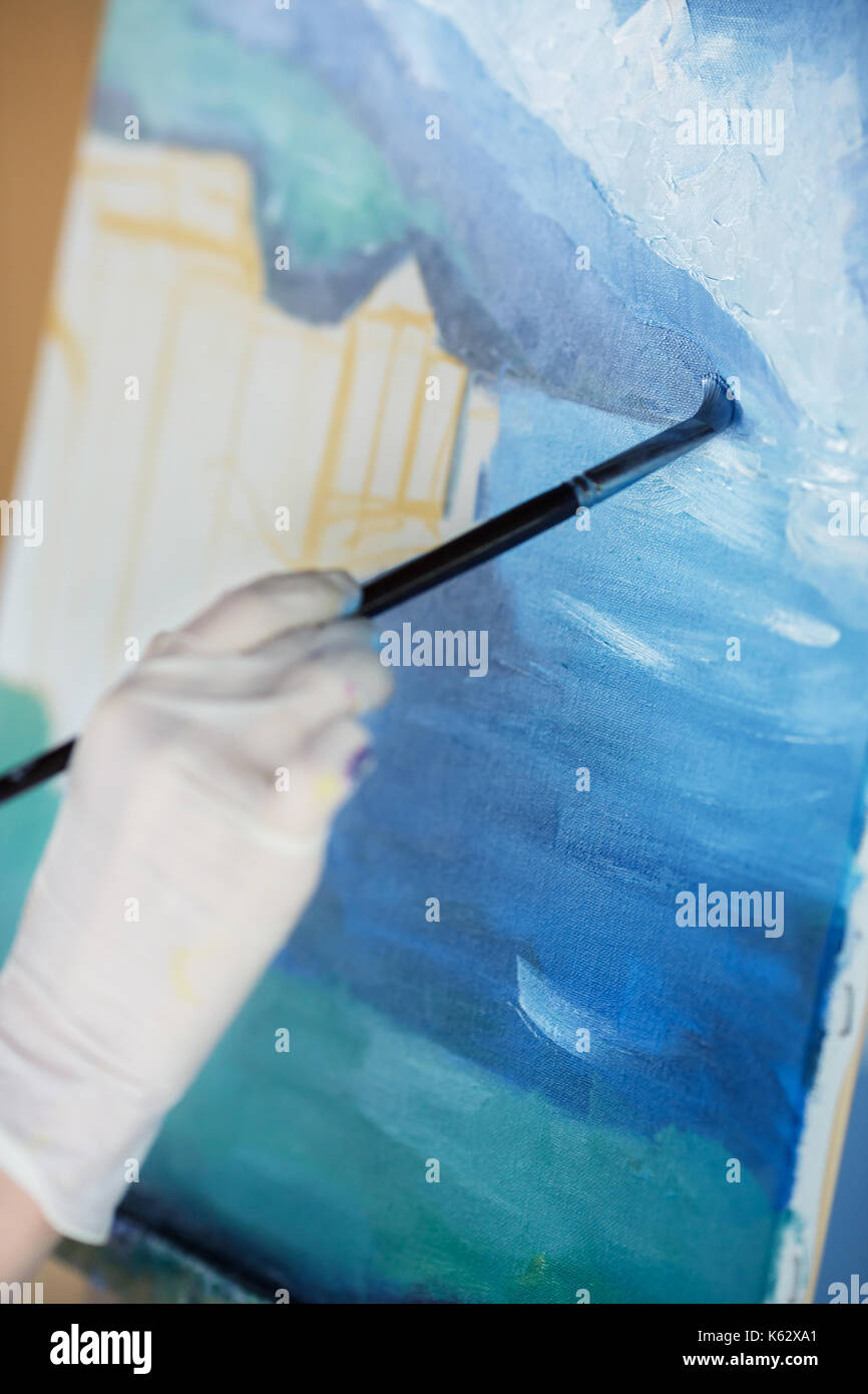 artist's hand with brush painting on canvas Stock Photo - Alamy