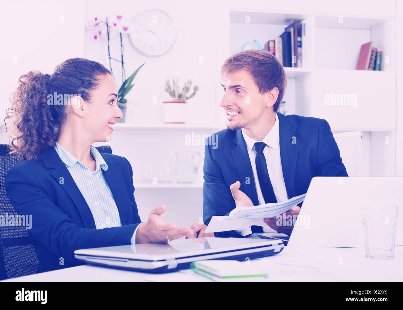 Two cheerful glad smiling business male and female assistants wearing ...