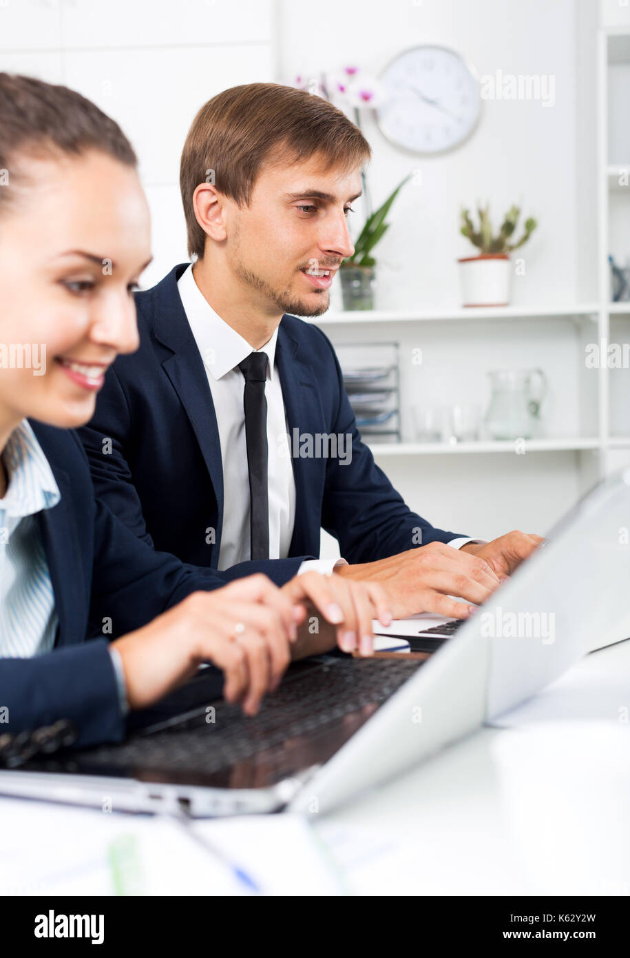 Two smiling business male and female assistants wearing formalwear ...