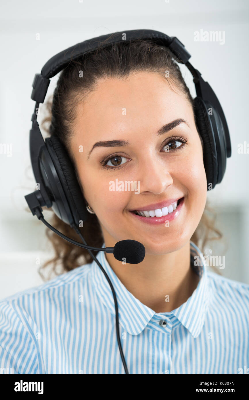 Positive call center operator working with client by headset and ...