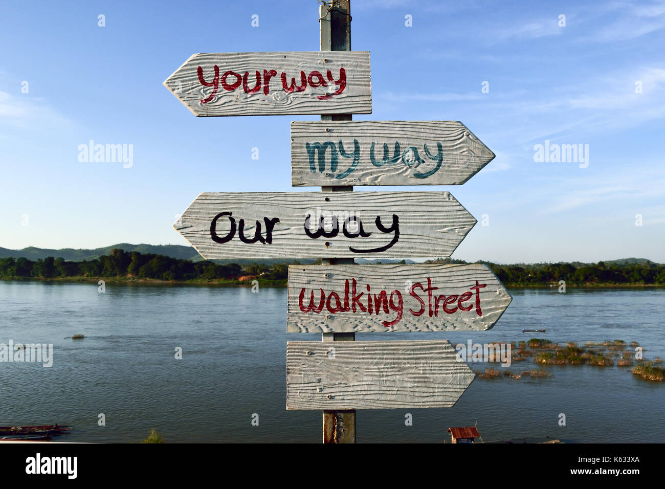 Direction sign saying your way, my way, our way with river background ...