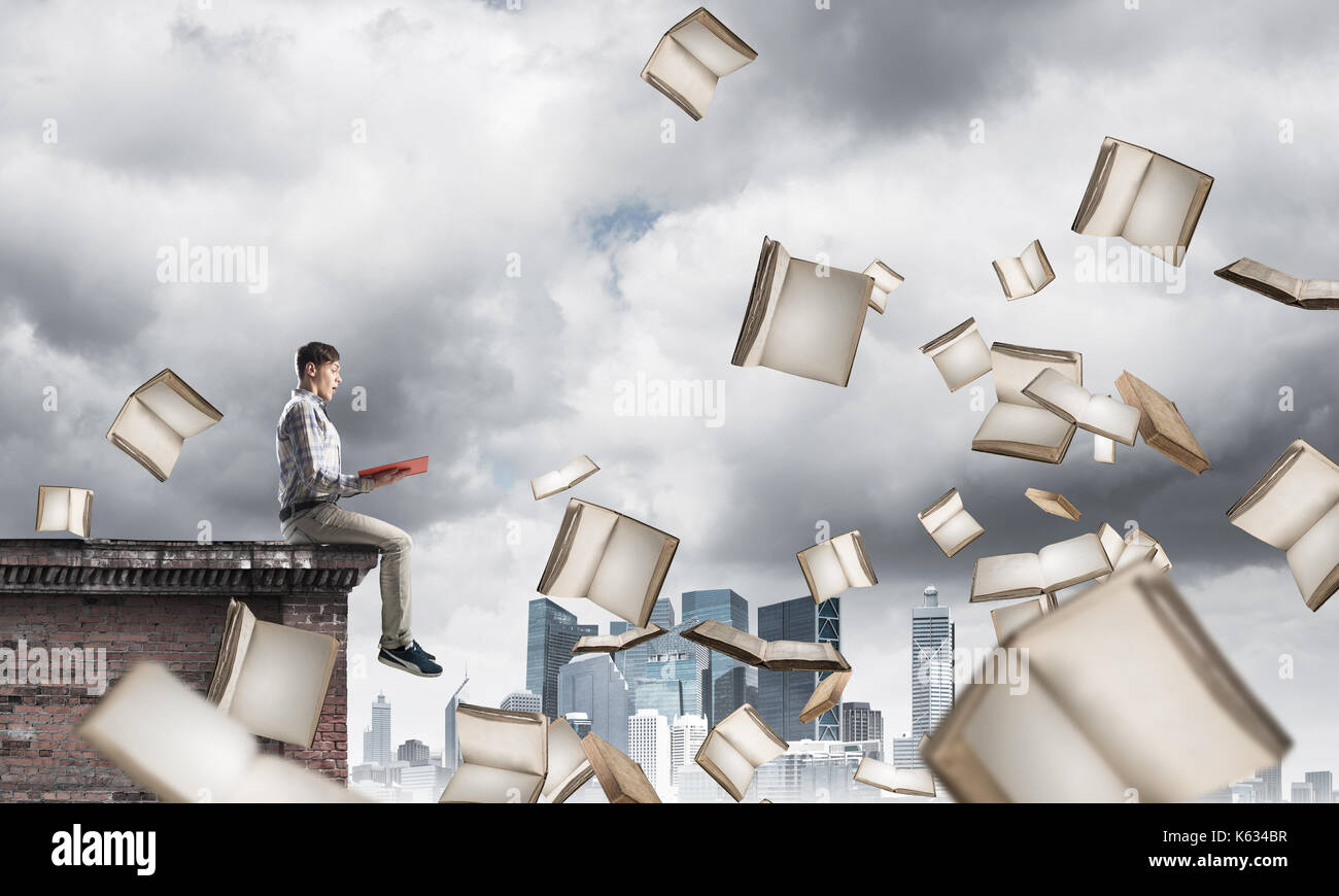 Man reading book and many of them flying in air Stock Photo - Alamy