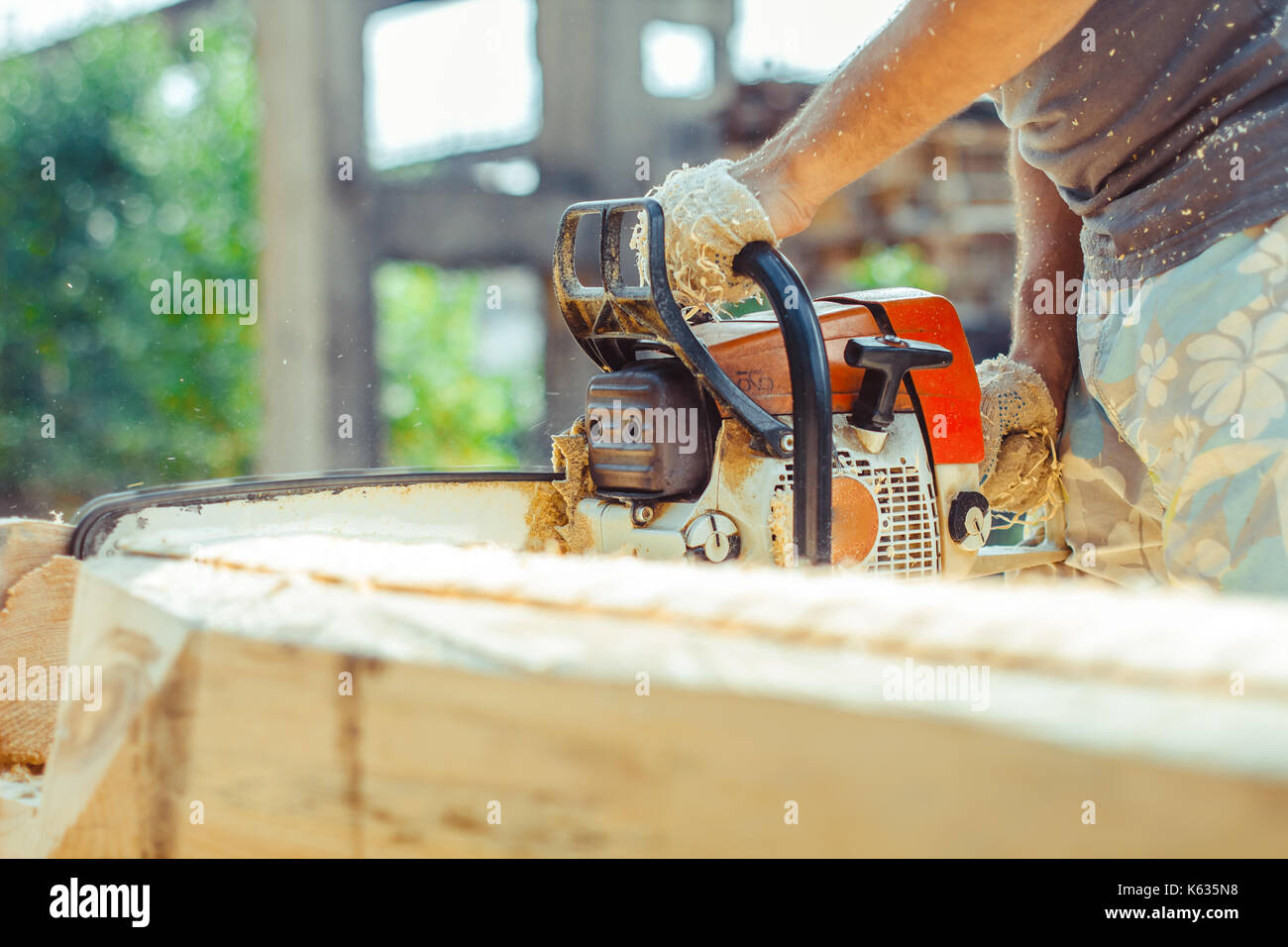 Man with a chainsaw cutting a tree for construction Stock Photo - Alamy