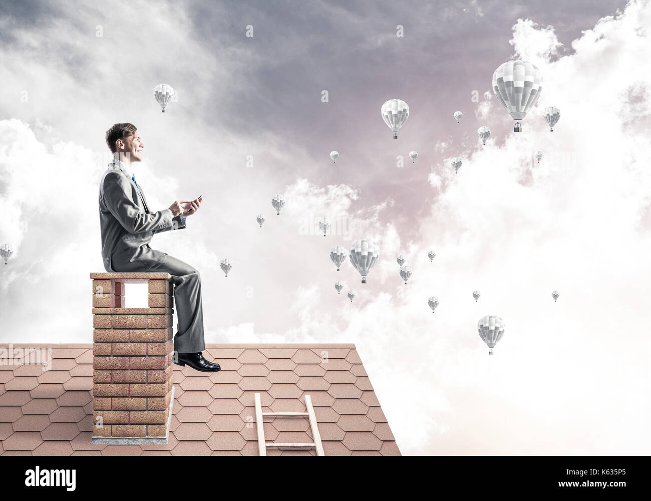 Man on brick roof using smartphone and aerostats flying in air Stock ...