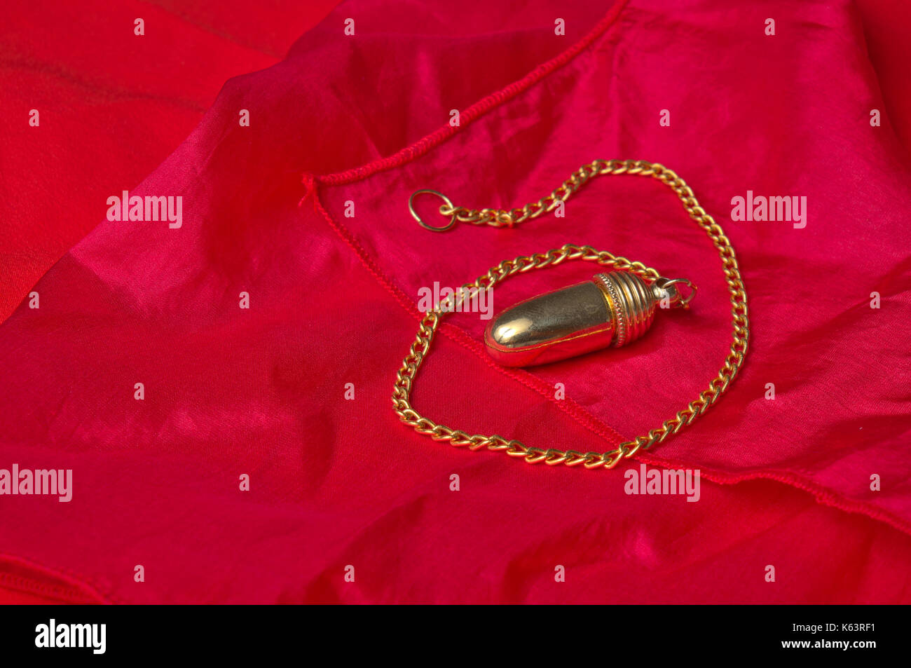 Pendulum on a red silk cloth. Vintage and esoteric theme Stock Photo ...