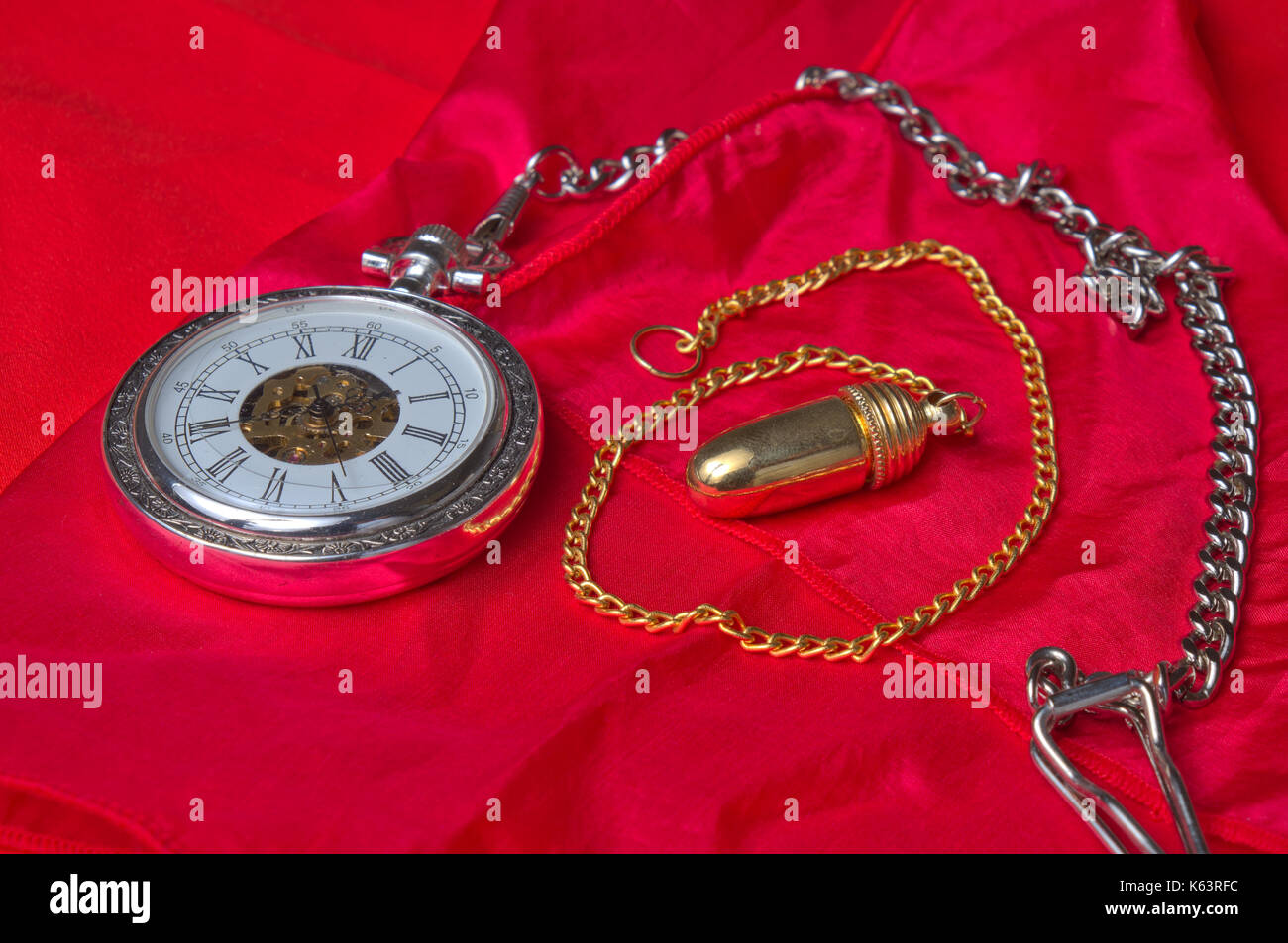 Pocket watch and pendulum on a red silk cloth. Vintage and esoteric ...