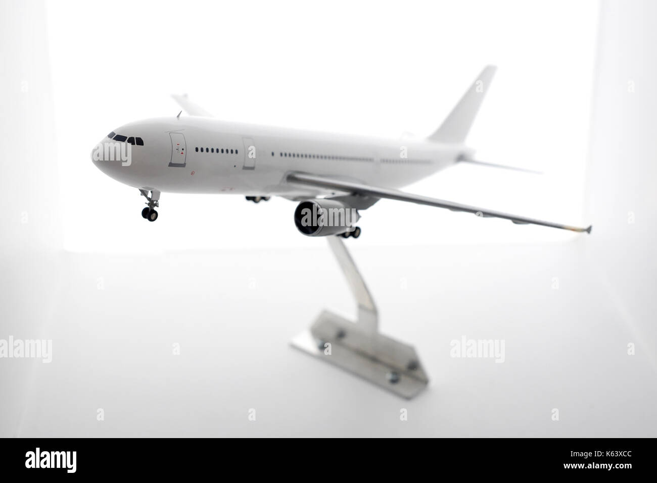 Model of passenger plane standing on stand against white background ...