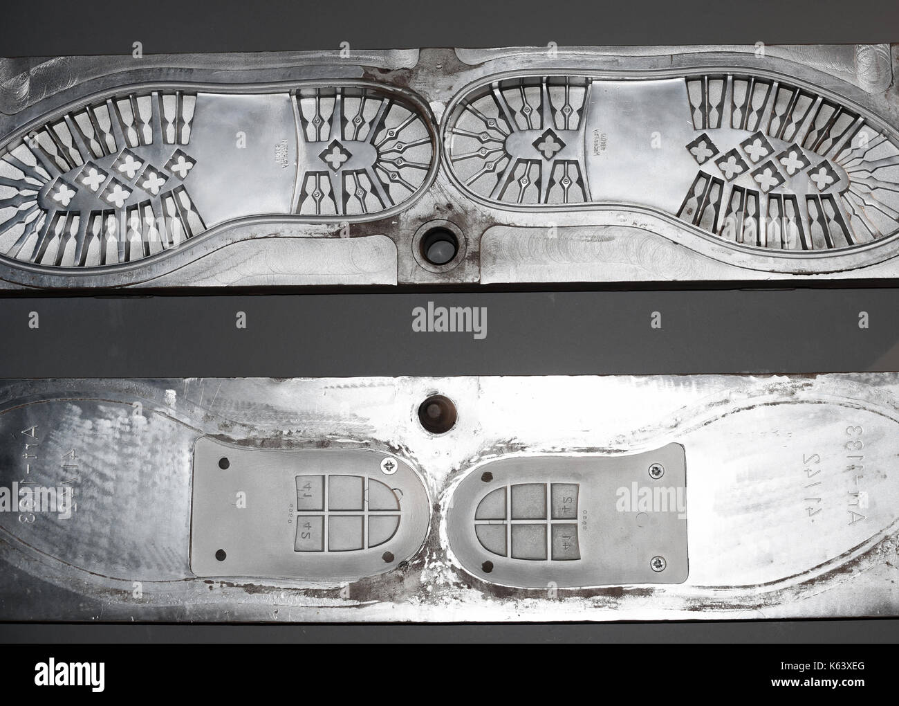 Metal mold for making the soles of shoes opened to show the two halves ...